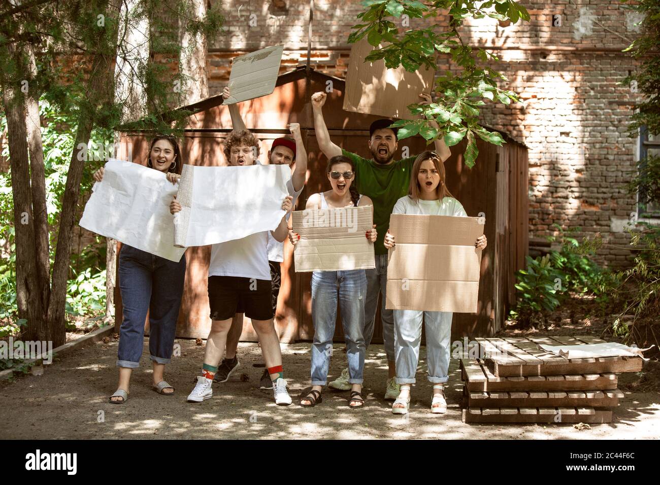 Diverse group of people protesting with blank sign. Protest against ...