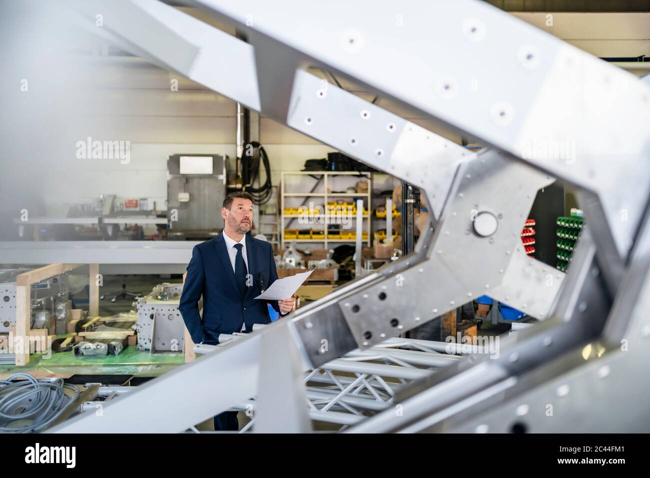 Mature businessman holding paper in a factory Stock Photo - Alamy