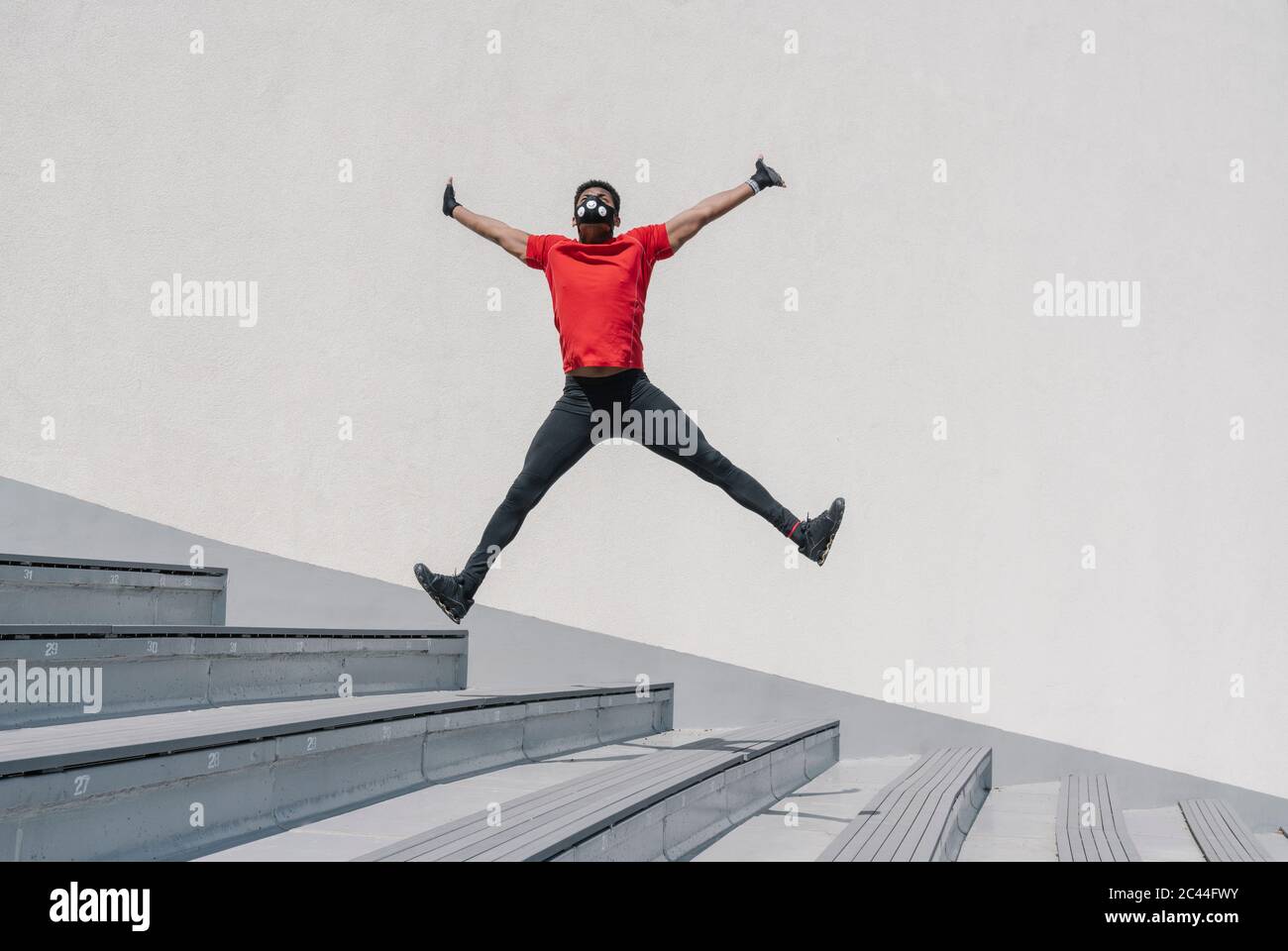 Sportsman wearing face mask jumping on stairs Stock Photo - Alamy