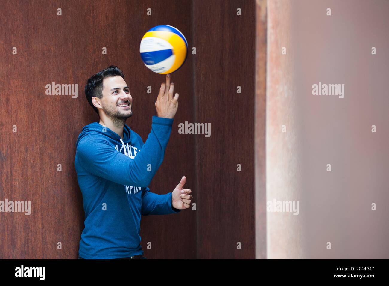Smiling man balancing ball on his finger Stock Photo - Alamy