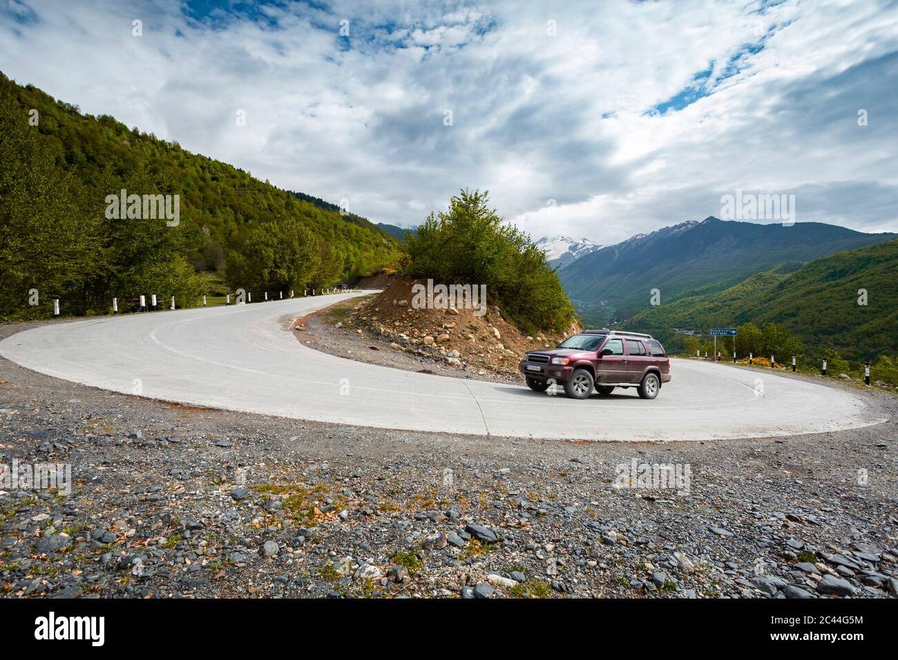 Georgia, 4x4 car passing hairpin turn on winding mountain road Stock ...