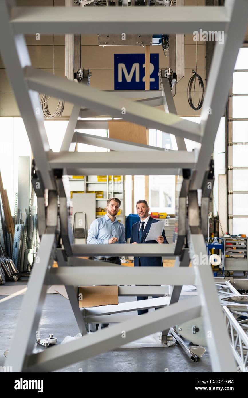 Two businessmen having meeting factory hall hi-res stock photography ...