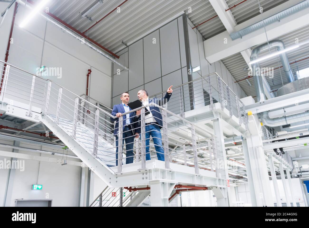 Two businessmen having a discussion in a factory Stock Photo - Alamy