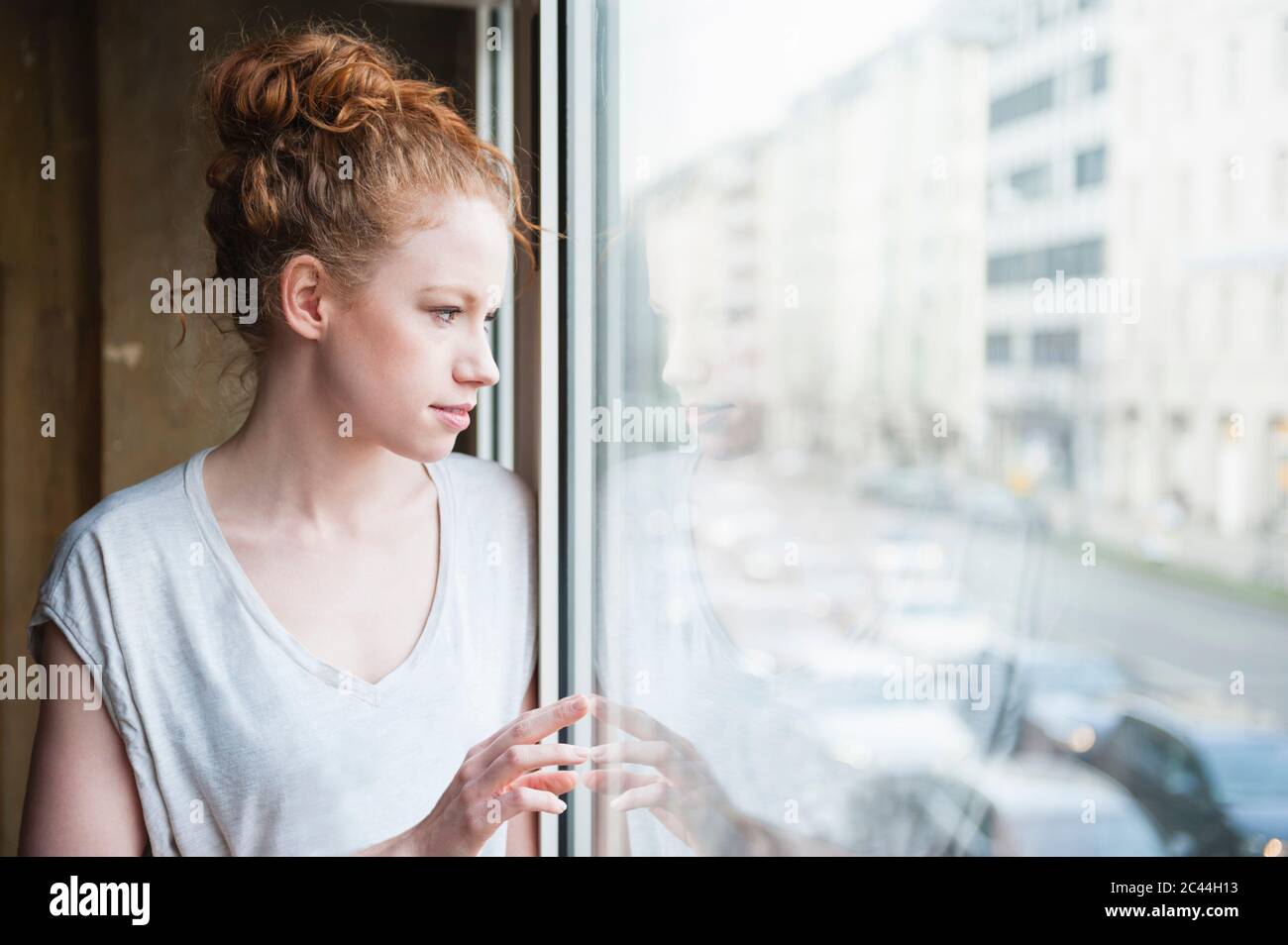 Thoughtful young woman through glass window hi-res stock photography ...