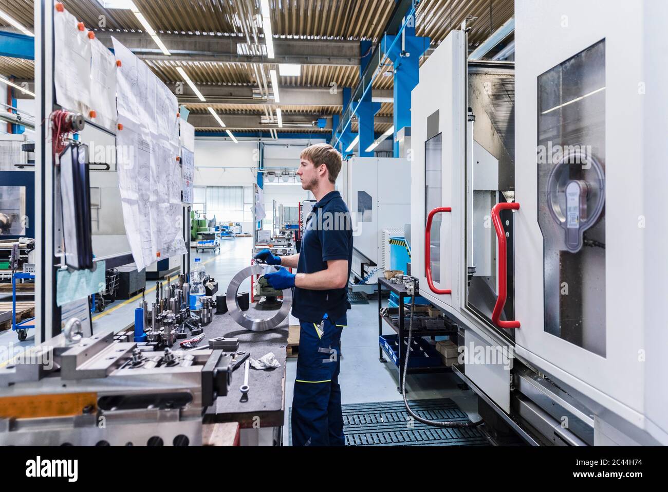 Man working at workbench in a metalworking factory Stock Photo - Alamy