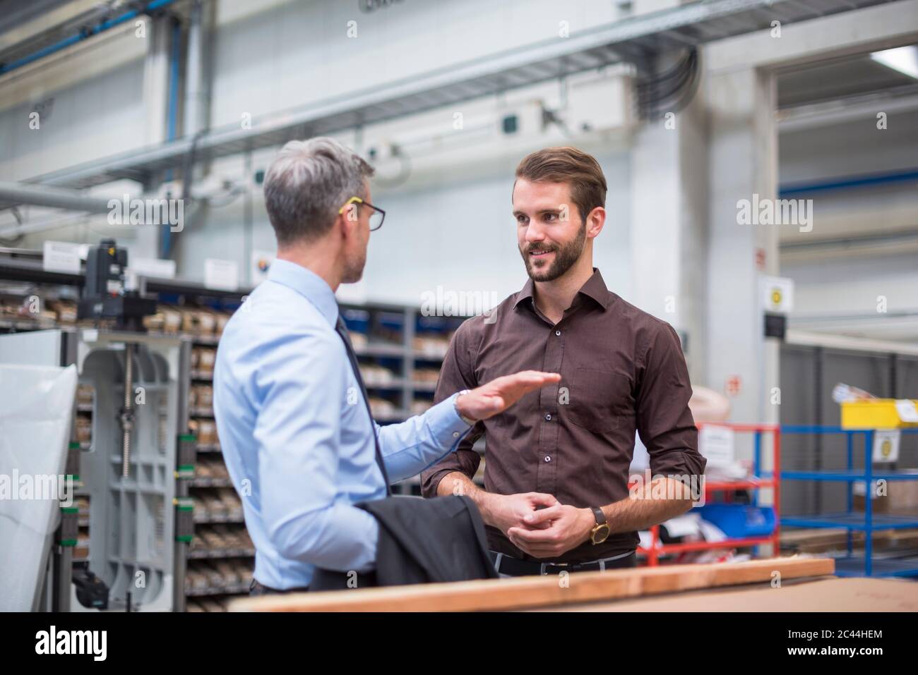 Two businessmen talking in a factory Stock Photo - Alamy