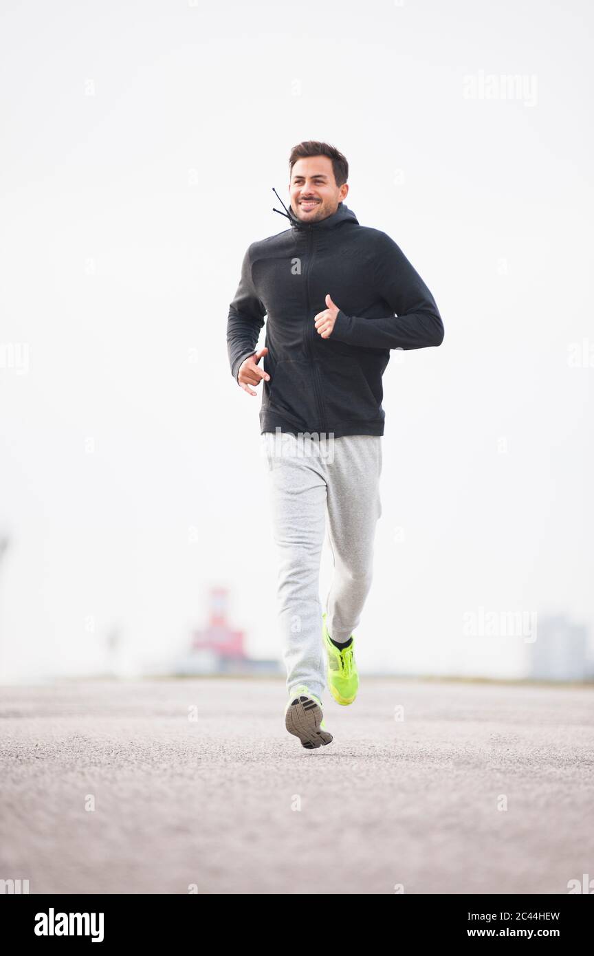 Young man running on a lane Stock Photo - Alamy