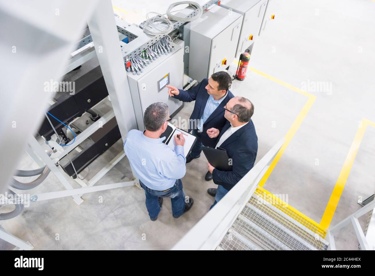 Three businessmen having a discussion in a factory Stock Photo - Alamy