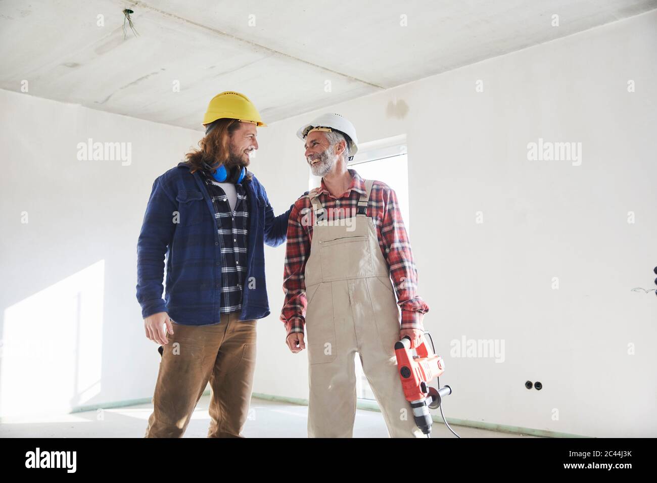 Construction workers with drill at construction site Stock Photo - Alamy