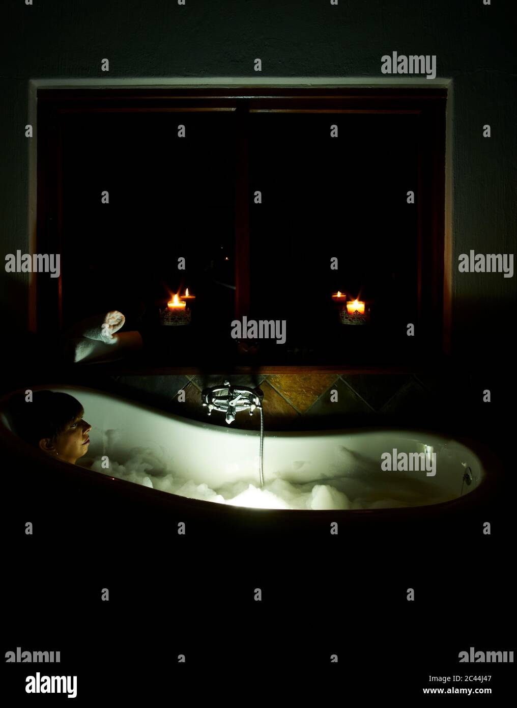 Woman relaxing in bath tub at night Stock Photo - Alamy