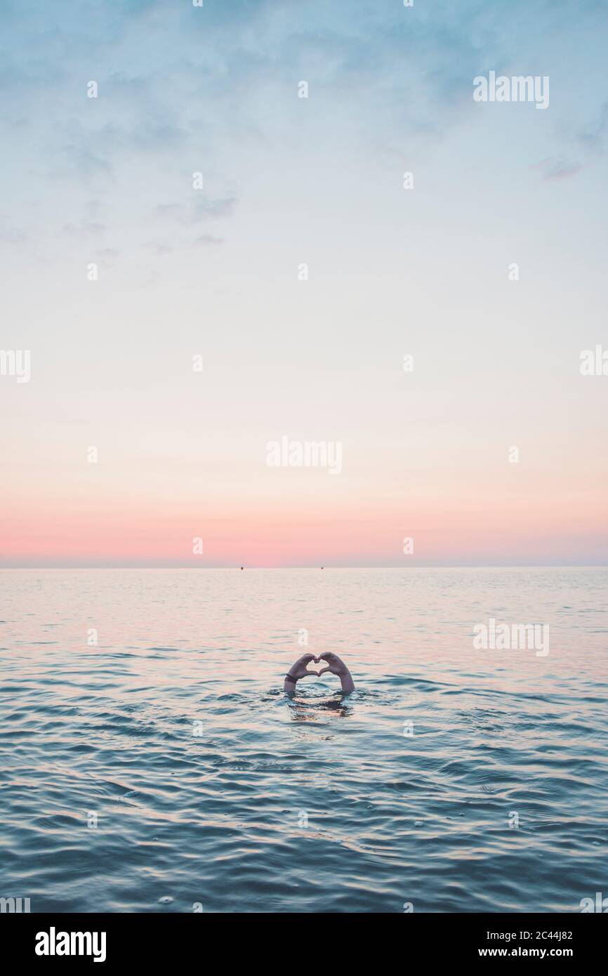 Hands shaping heart over water surface of the sea Stock Photo - Alamy