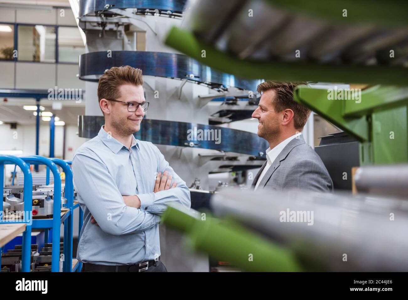 Two businessmen talking in factory Stock Photo - Alamy
