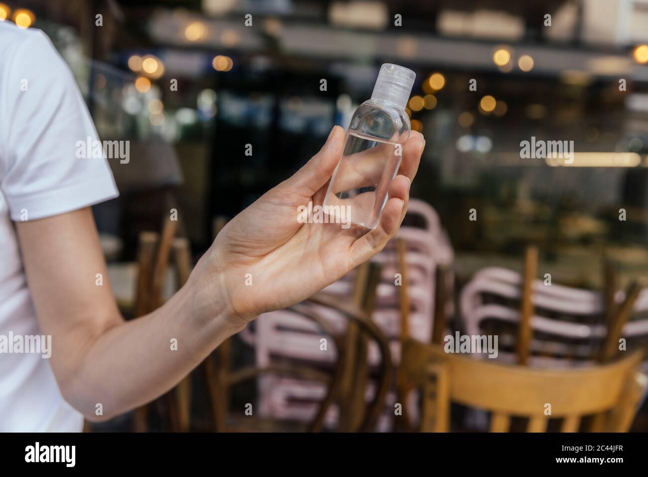 Woman's hand holding flask with sanitizer Stock Photo - Alamy