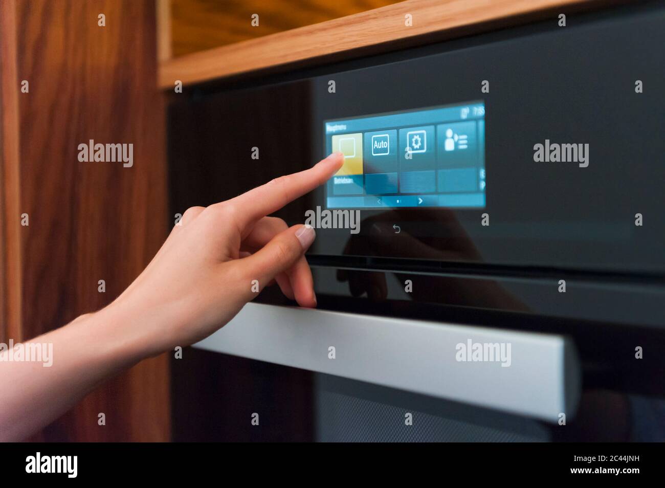 Woman hand touching oven's digital display in kitchen Stock Photo - Alamy