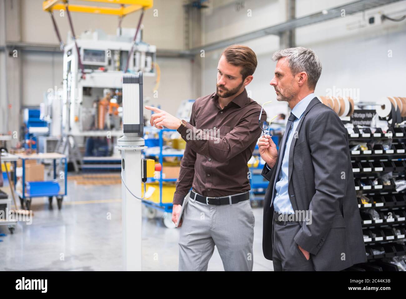 Two businessmen talking in a factory Stock Photo - Alamy