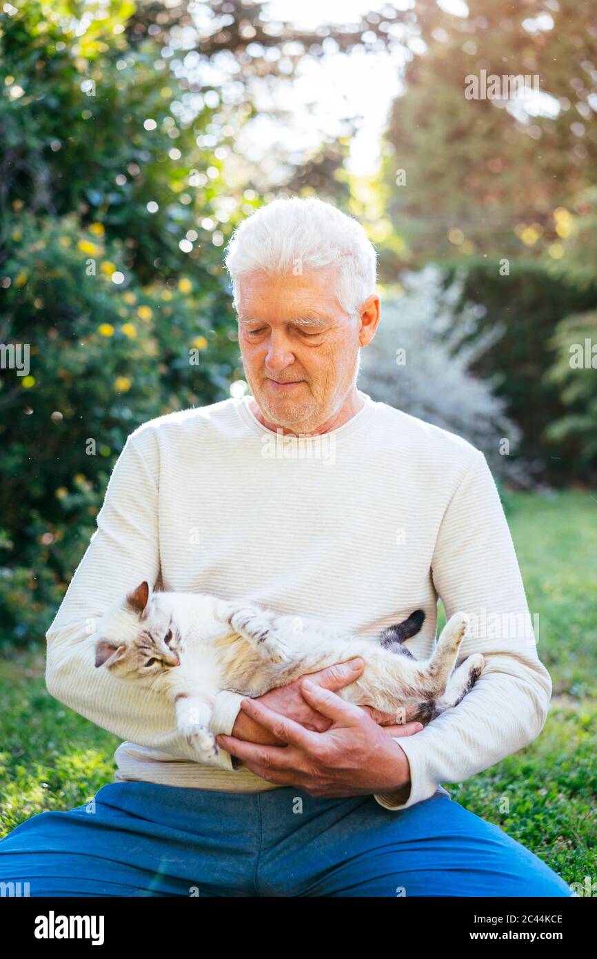 Senior man cuddling with his cat in garden Stock Photo - Alamy