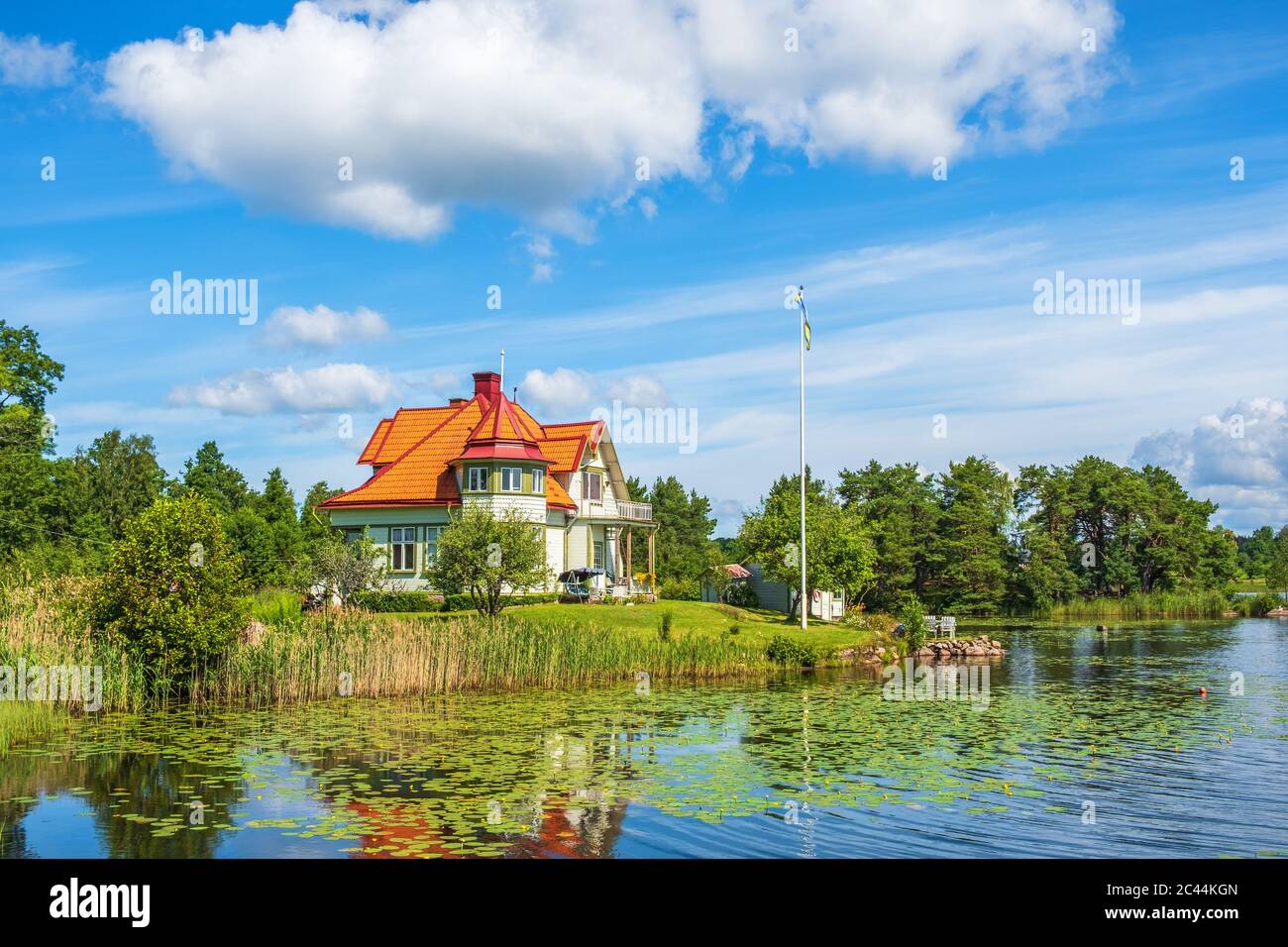 Summer idyll with a house on a hill by a beautiful lake Stock Photo - Alamy