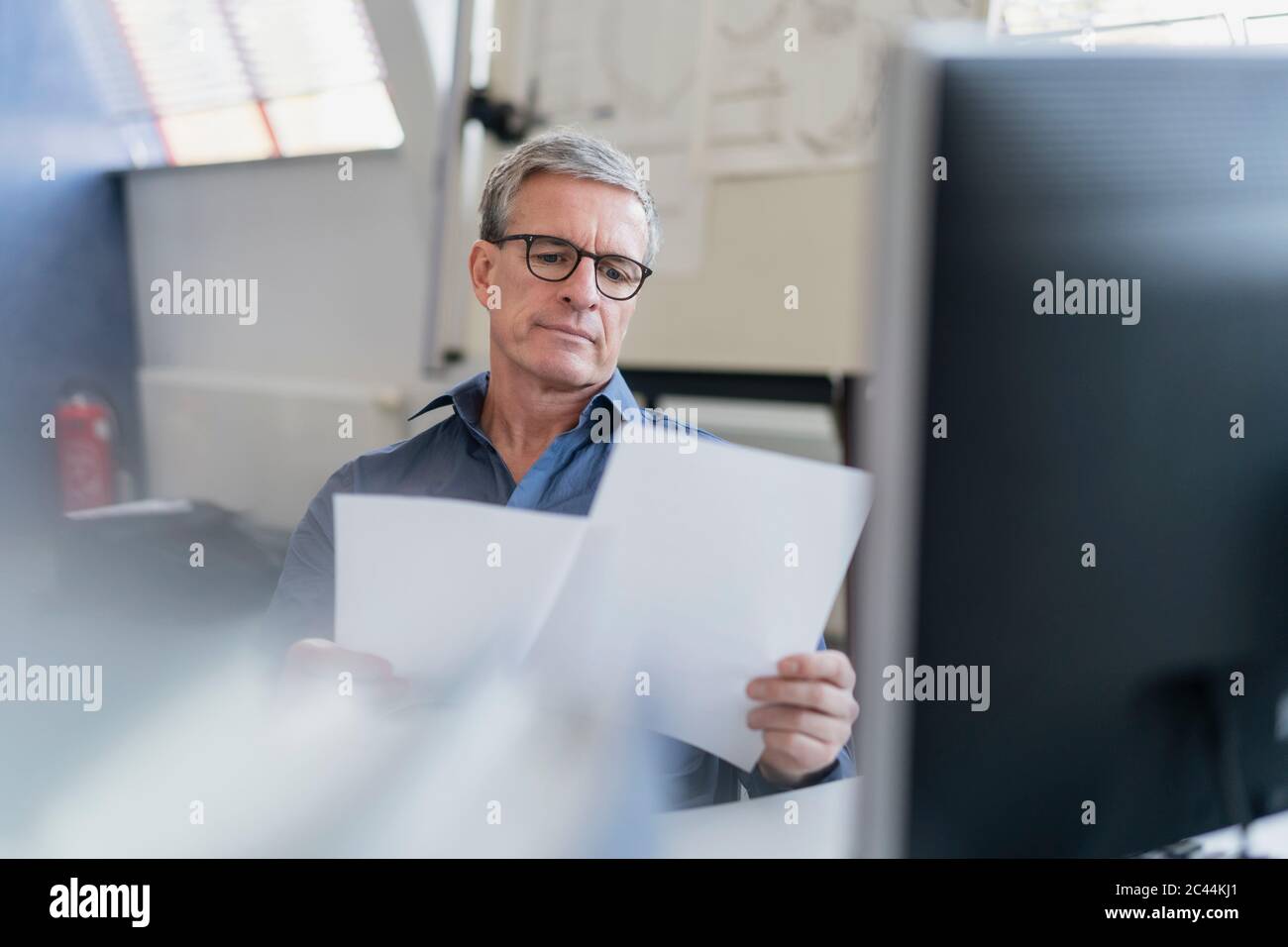 Professional man sitting desk reading hi-res stock photography and ...