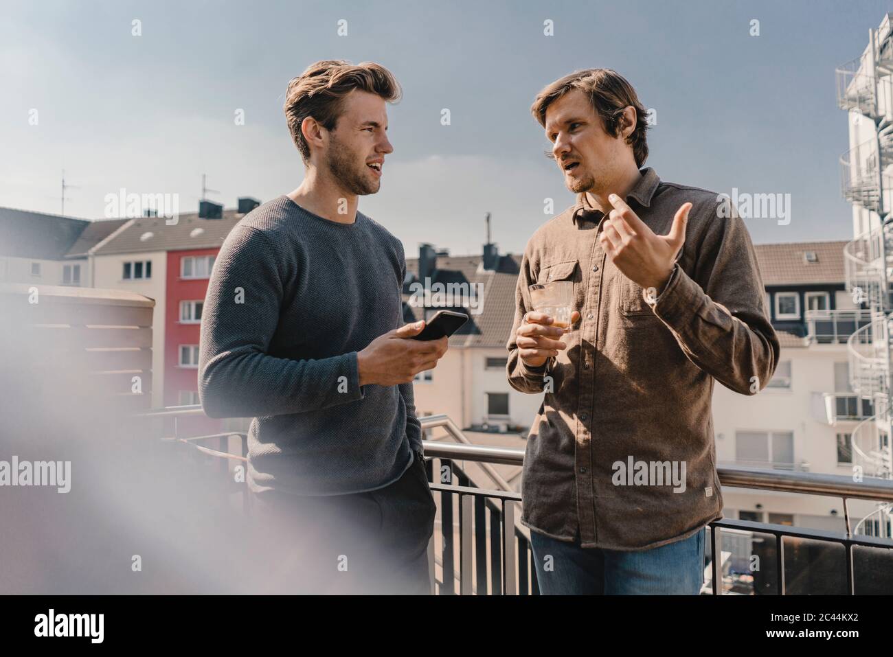 Two people talking on balcony hi-res stock photography and images - Alamy