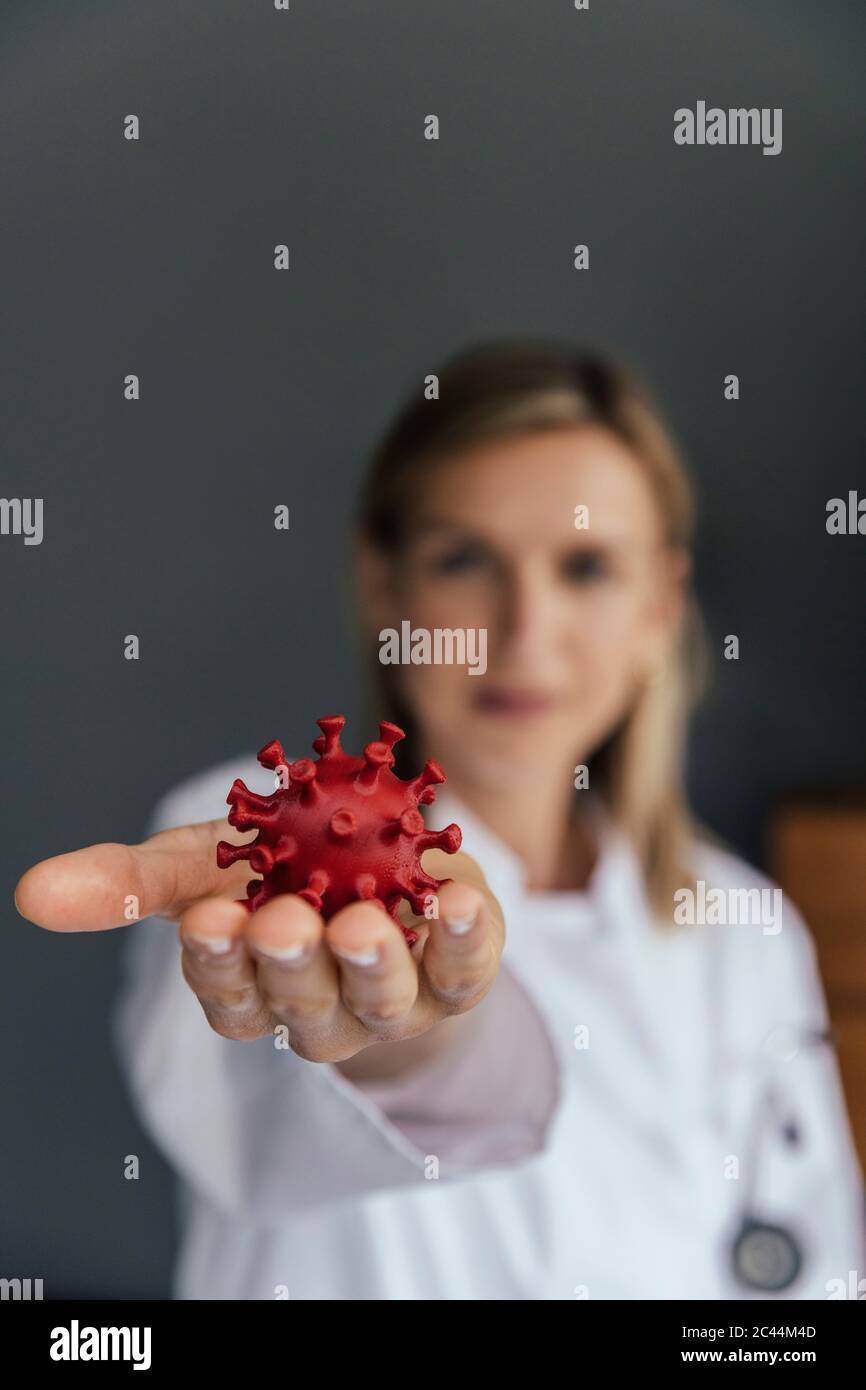 Hand of female scientist holding 3D model of SARS-CoV-2 virus, close-up ...