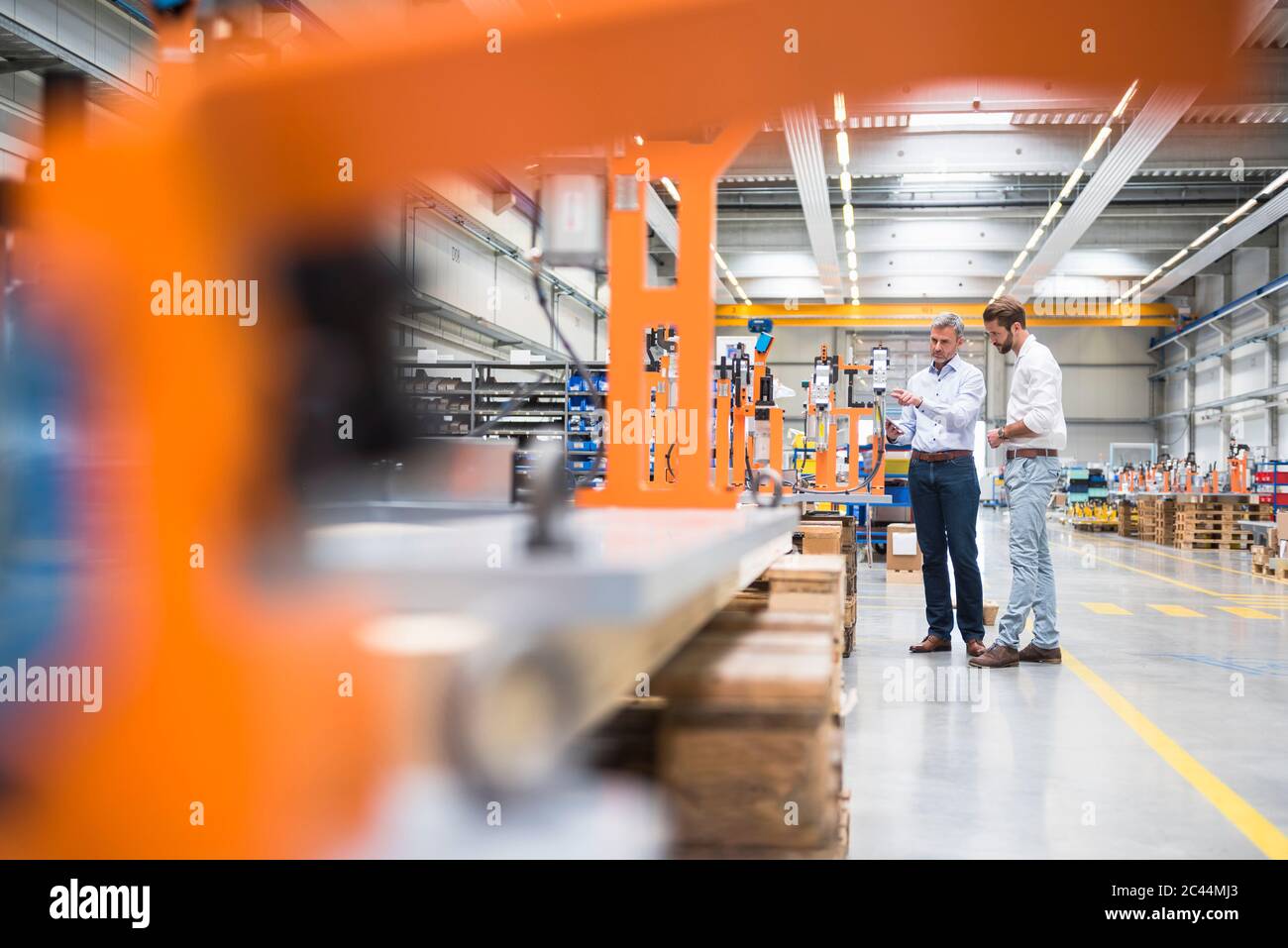 Two men talking on factory shop floor Stock Photo - Alamy