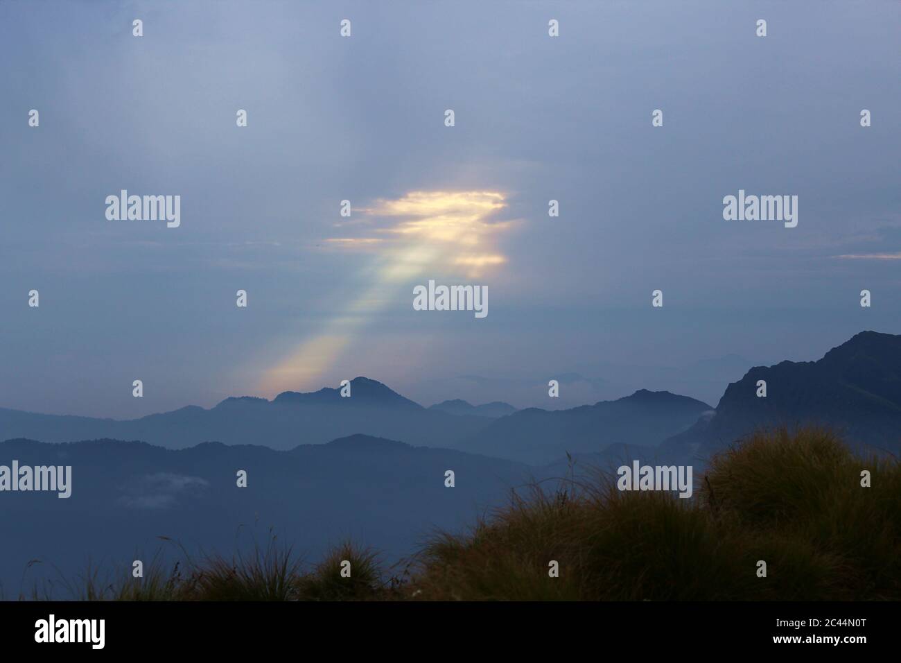 lower Himalayan mountain peaks with sun rays come out from the hole in ...