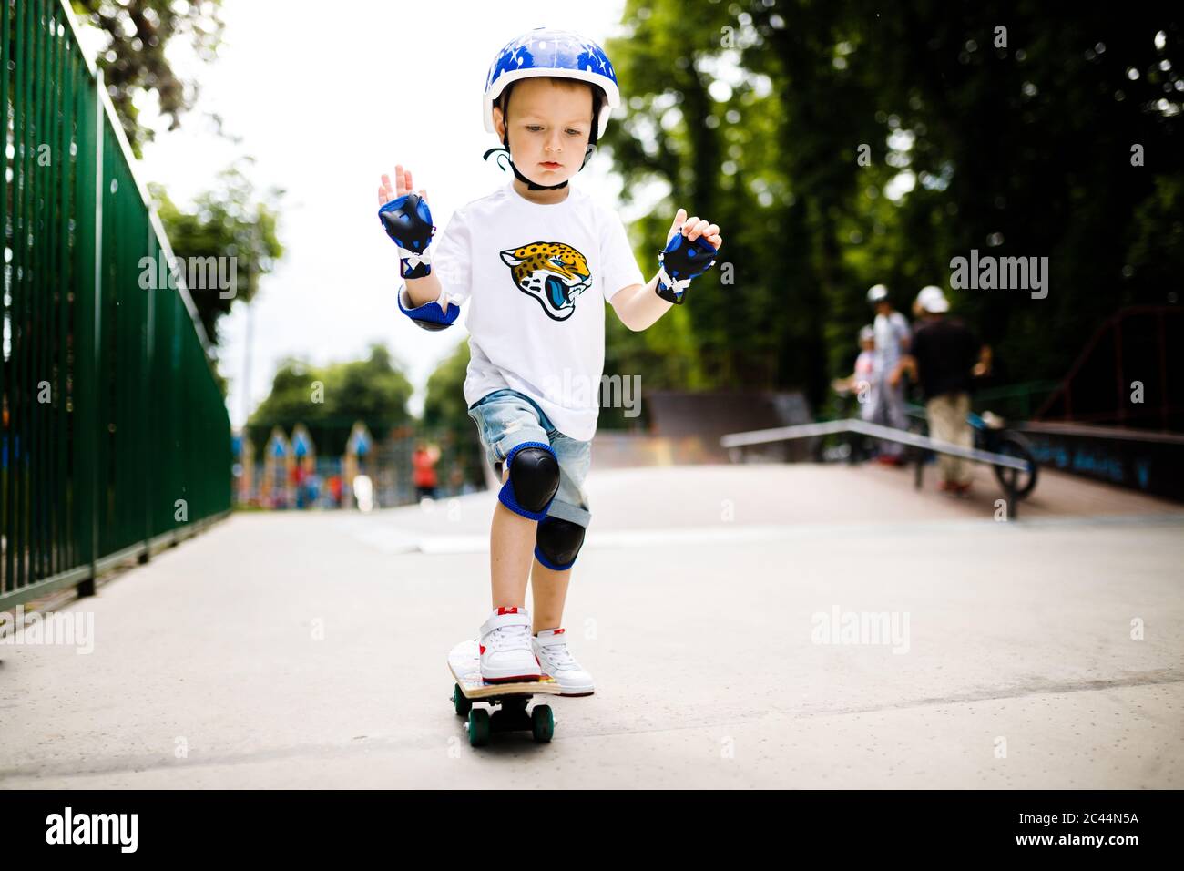 Boy with a skate in a skate park. The boy learns to skate, in full ...