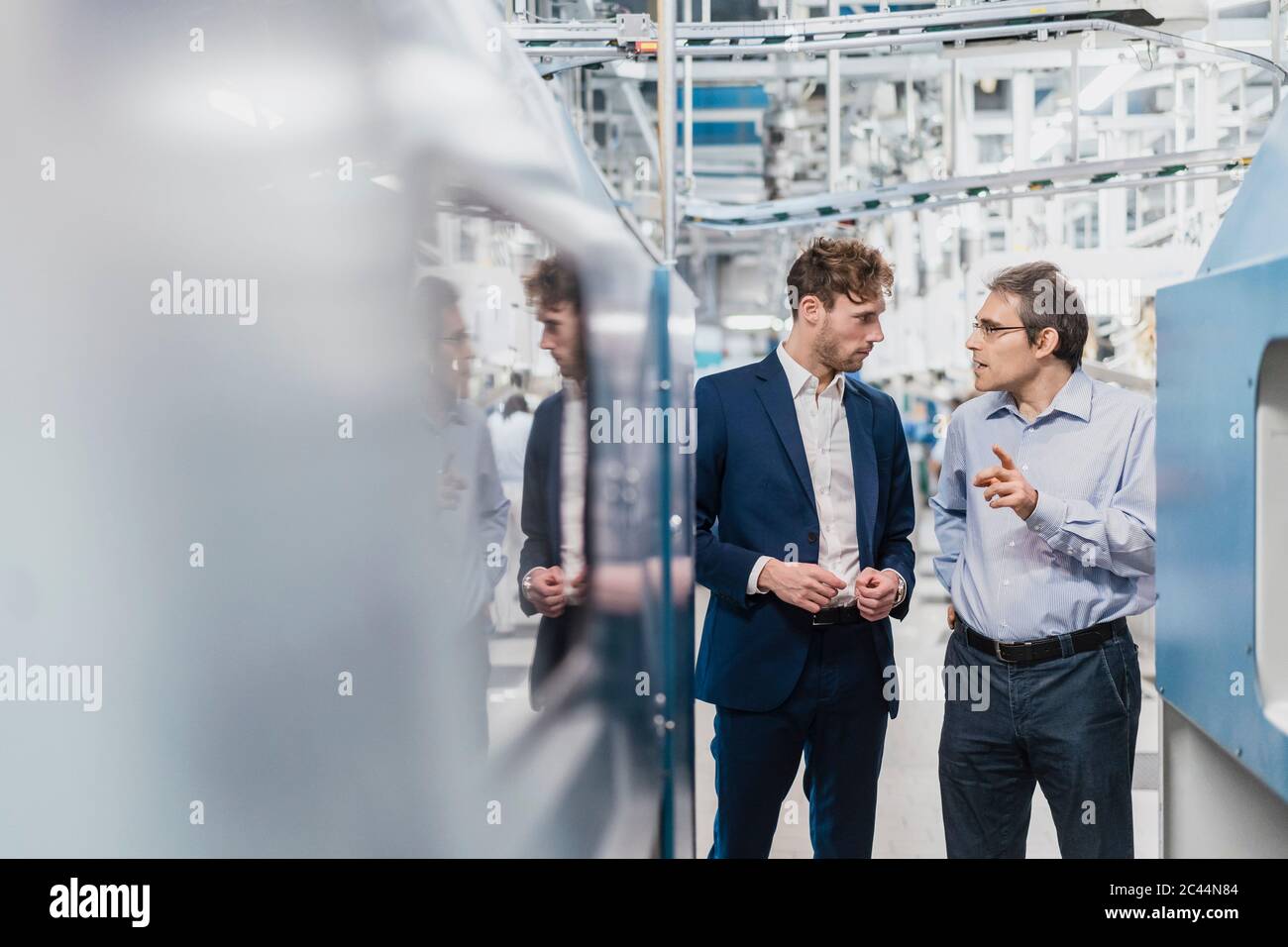 Two businessmen having meeting factory hall hi-res stock photography ...