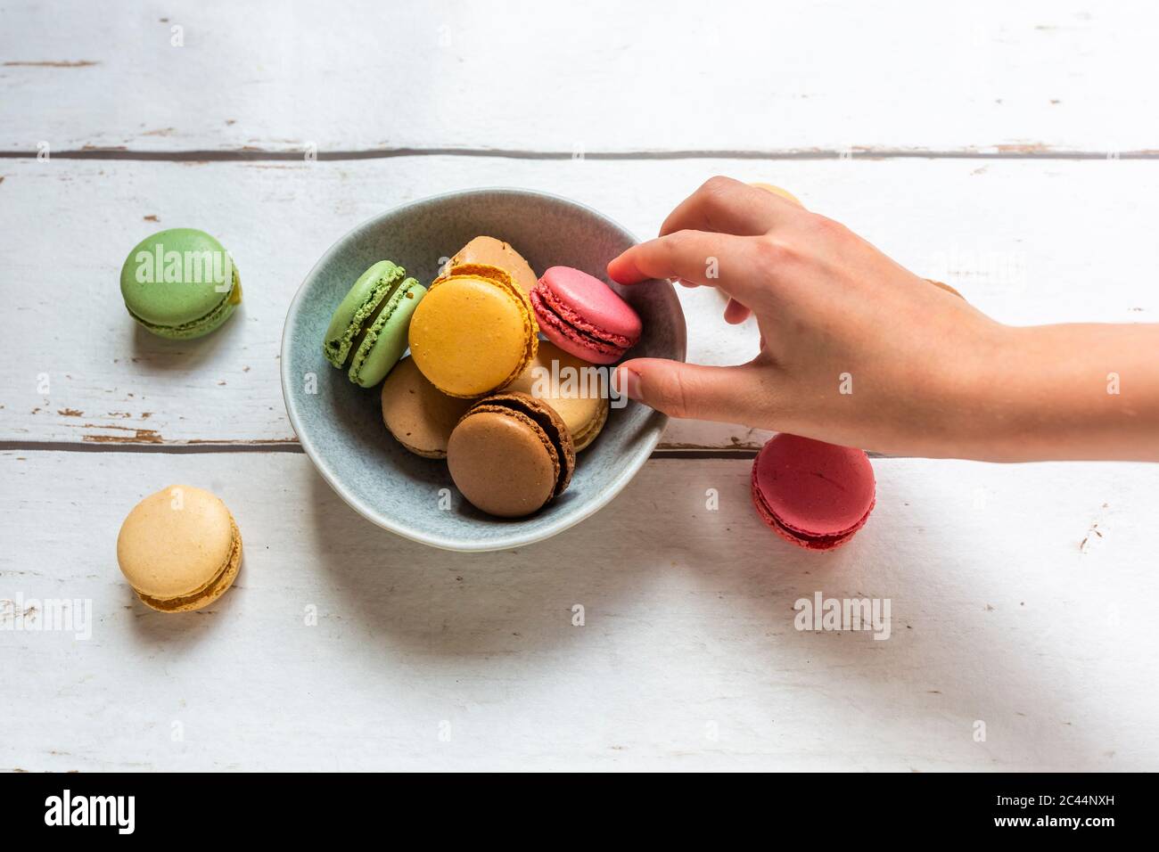 Hand of girl picking up macaroon biscuit Stock Photo - Alamy