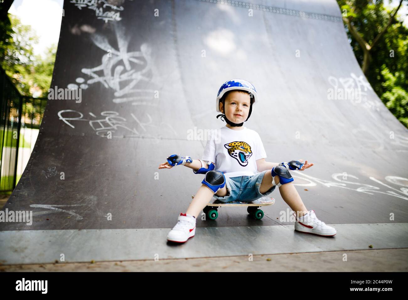 Boy with a skate in a skate park. The boy learns to skate, in full ...