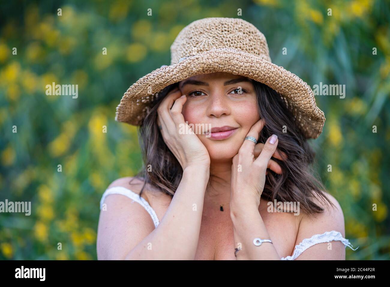 Portrait of smiling beautiful young woman touching her face, Alicante ...