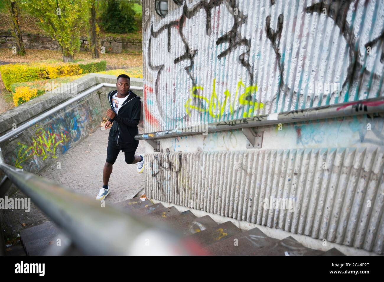 Young man jogging on steps Stock Photo - Alamy