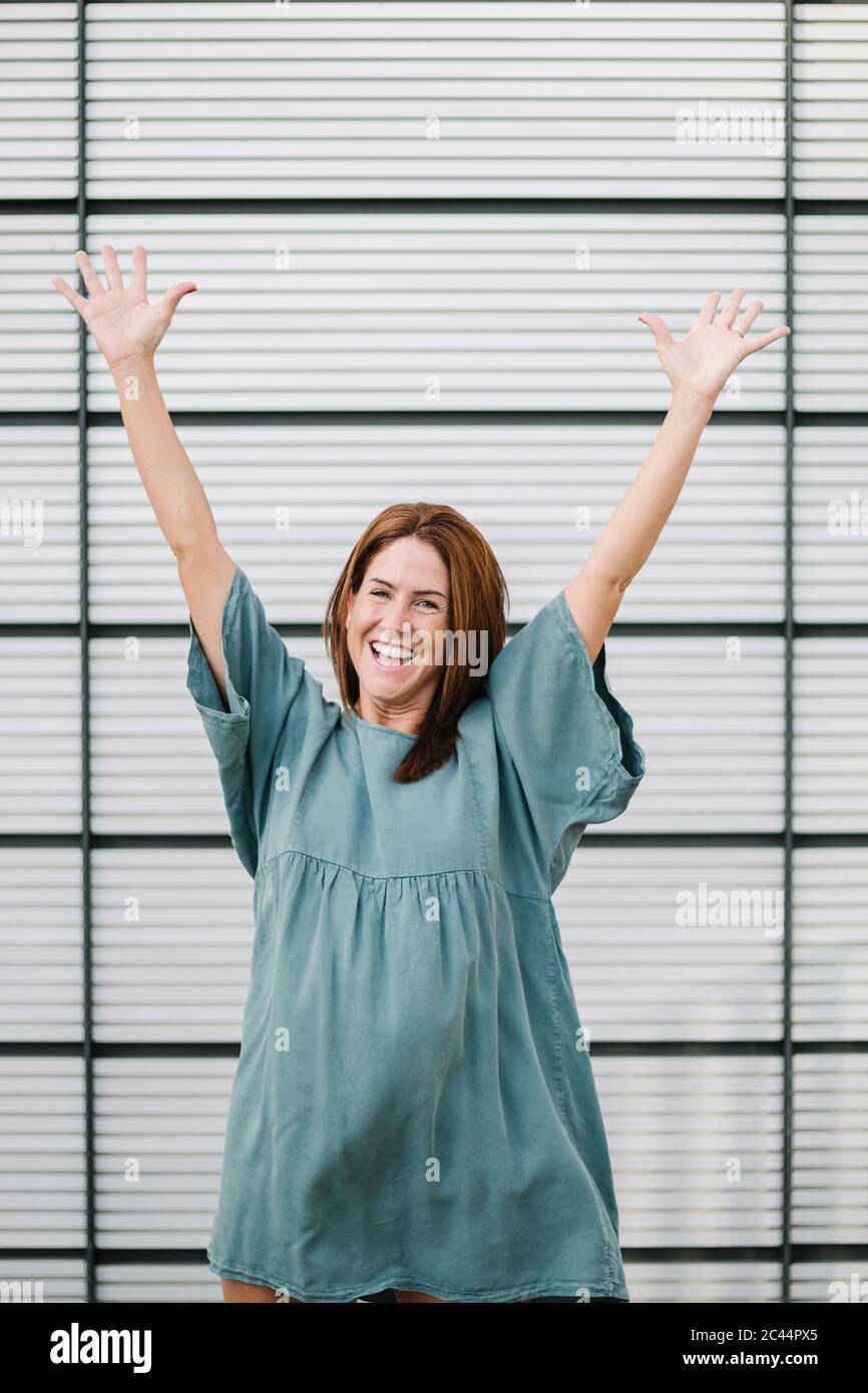 Euphoric woman in front of a wall Stock Photo - Alamy