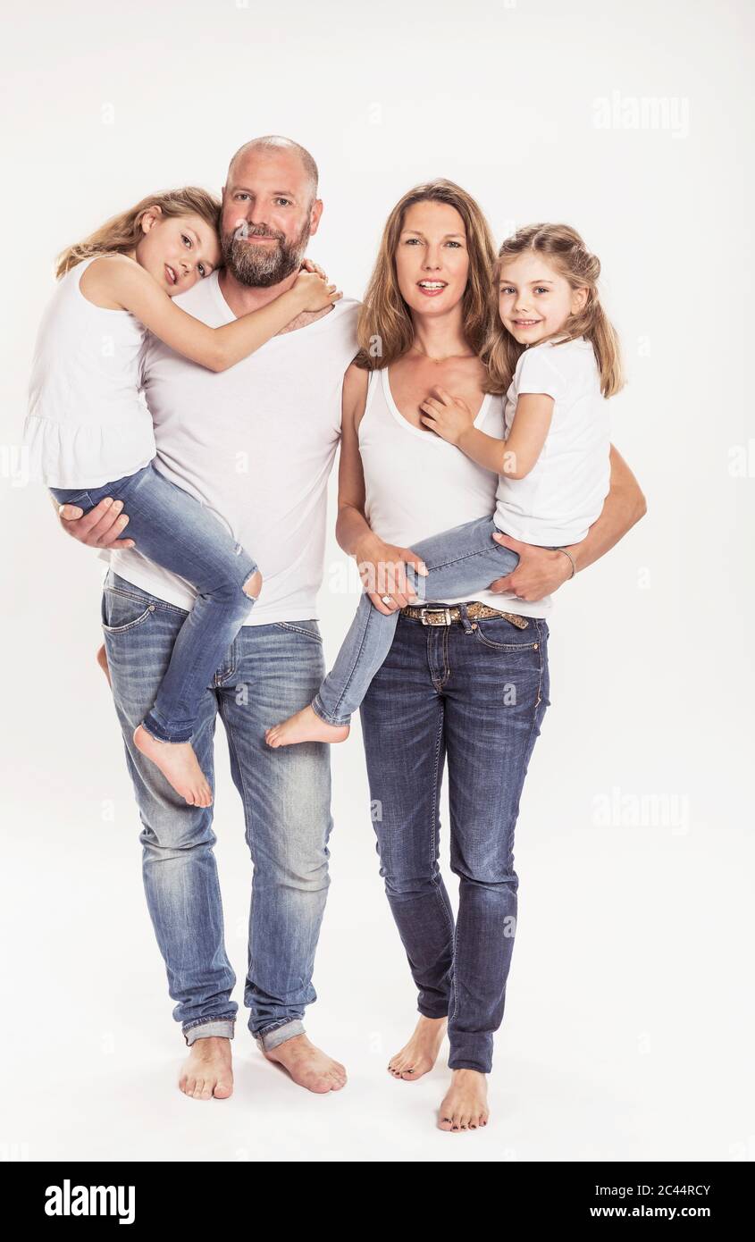 Portrait of family with two daughters in front of white background ...