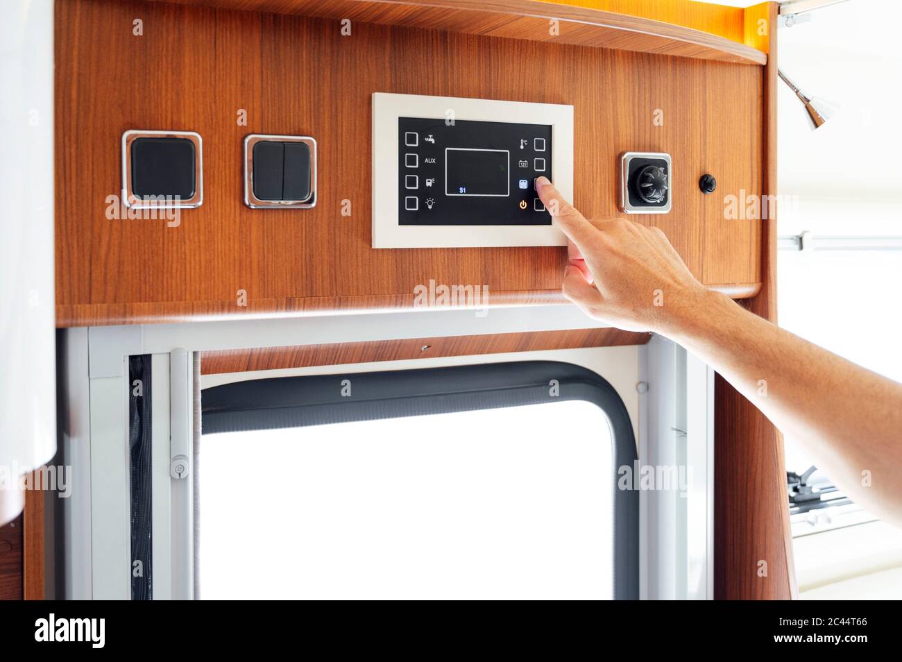 Hand of man pressing button on motor home control panel Stock Photo - Alamy