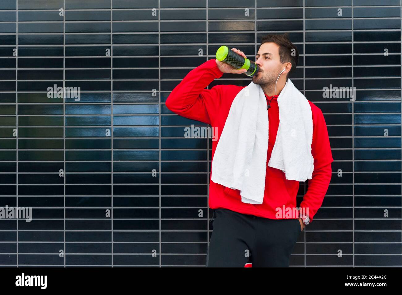 Young man having a break from workout drinking from bottle Stock Photo ...