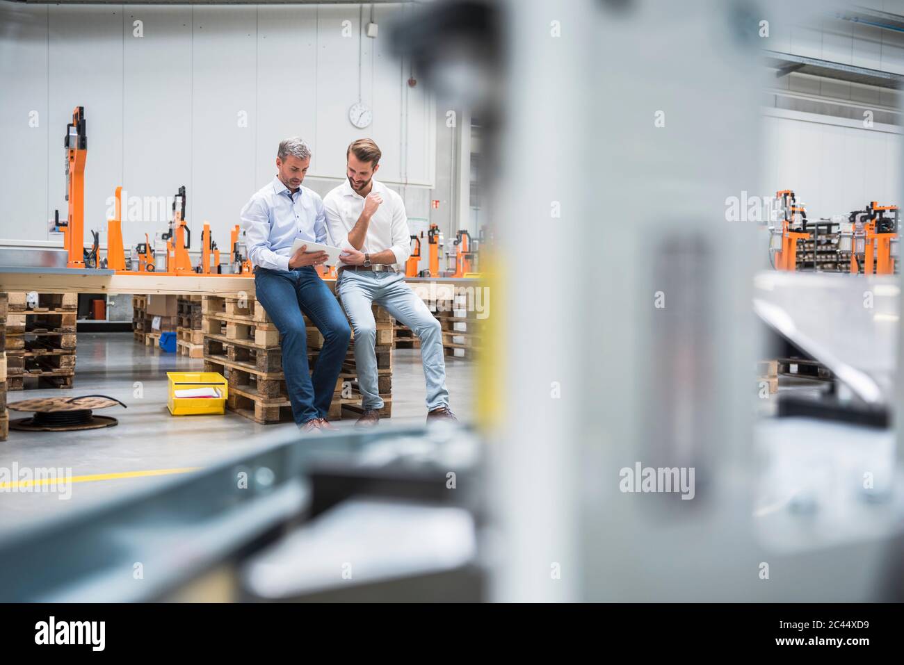 Two men sharing tablet on factory shop floor Stock Photo - Alamy