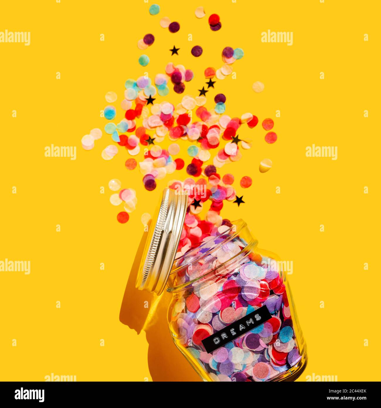 Colorful confetti spilling from glass jar Stock Photo - Alamy
