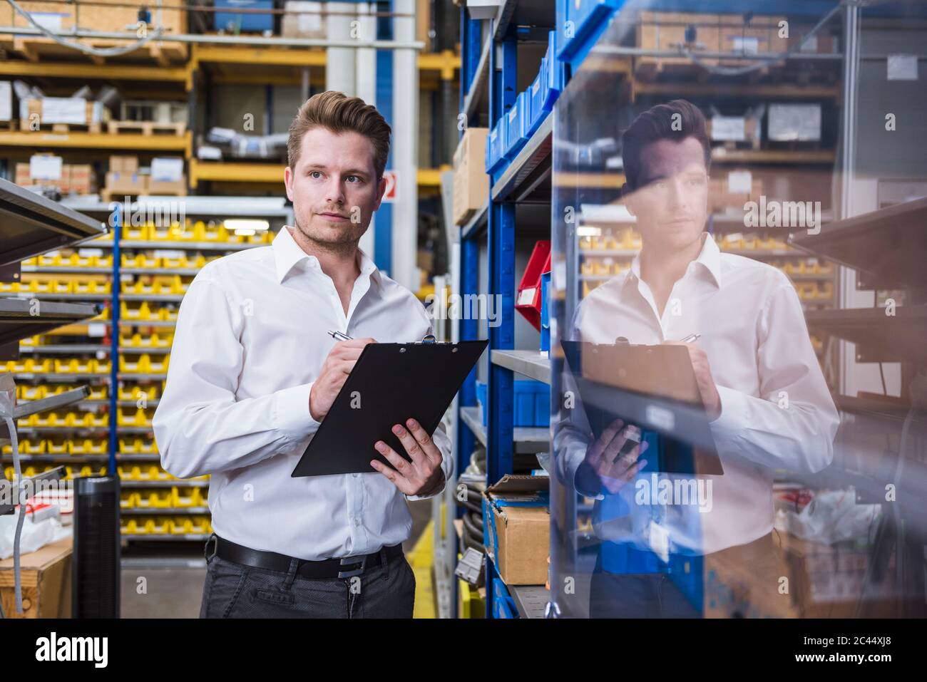 Man with clipboard taking notes in factory Stock Photo - Alamy