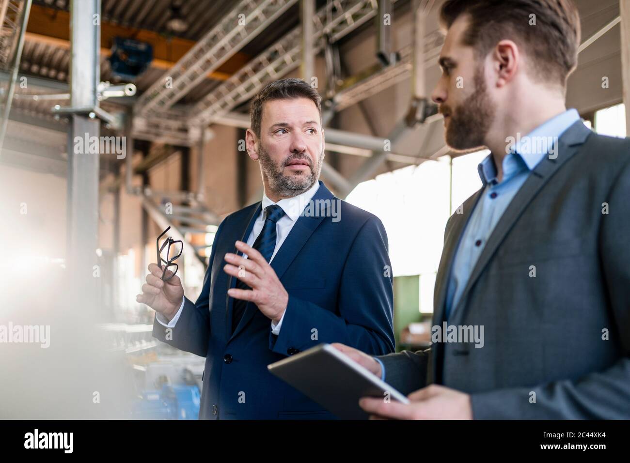 Two businessmen with tablet having a meeting in a factory Stock Photo ...