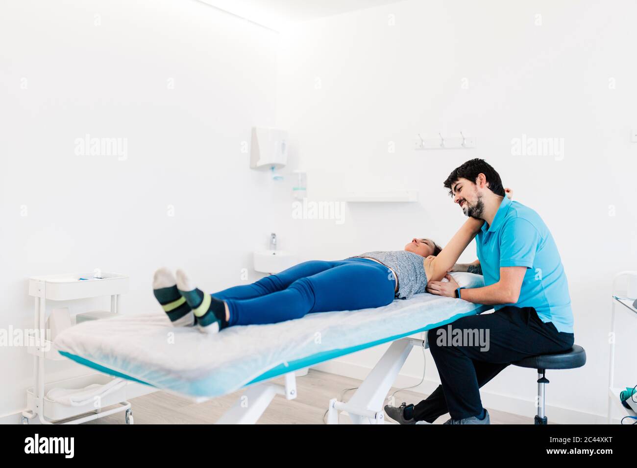 Visually impaired physical therapist treating woman's hand in clinic ...
