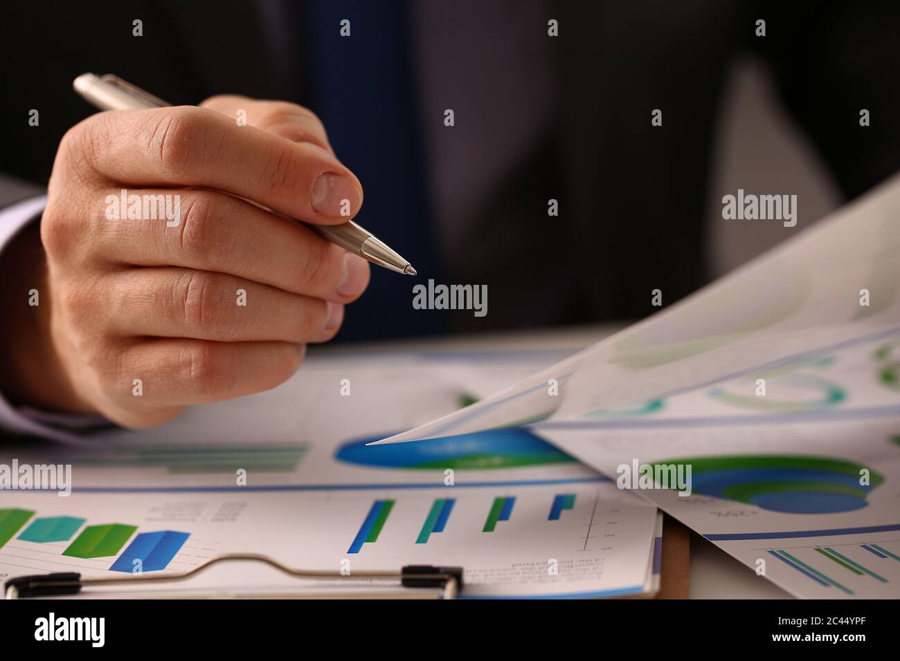 Male worker analyzing statistics report at work Stock Photo - Alamy