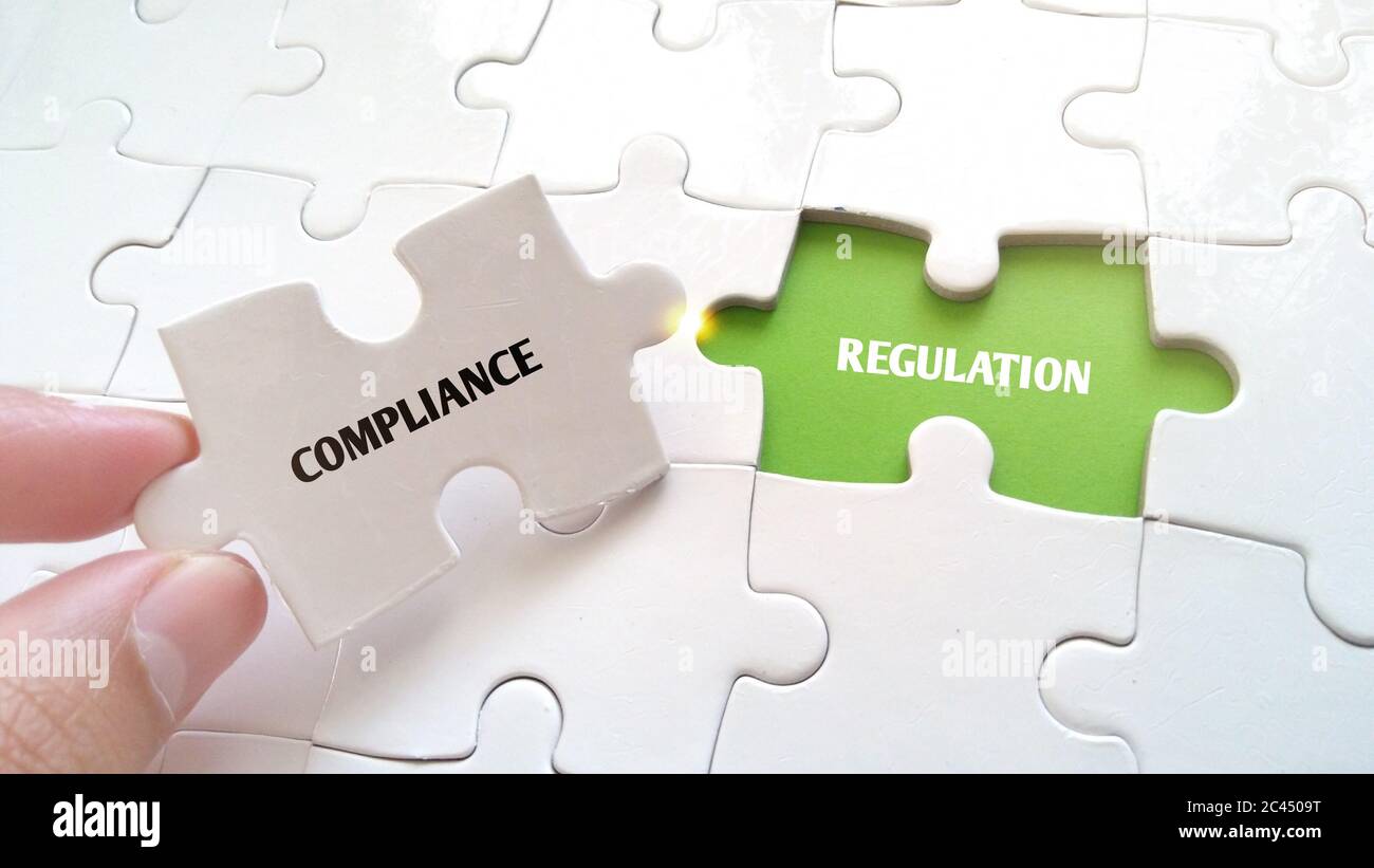 hand and missing puzzle with COMPLIANCE REGULATION WORD Stock Photo - Alamy