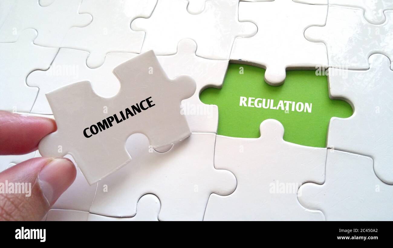 hand and missing puzzle with COMPLIANCE REGULATION WORD Stock Photo - Alamy