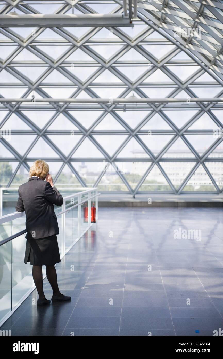 Woman is leaning against a railing Stock Photo - Alamy