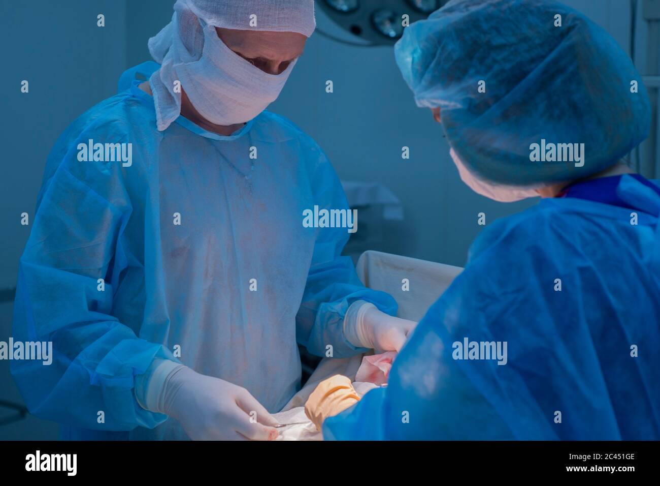 Children's surgeons perform urological surgery. A man and a woman in a ...