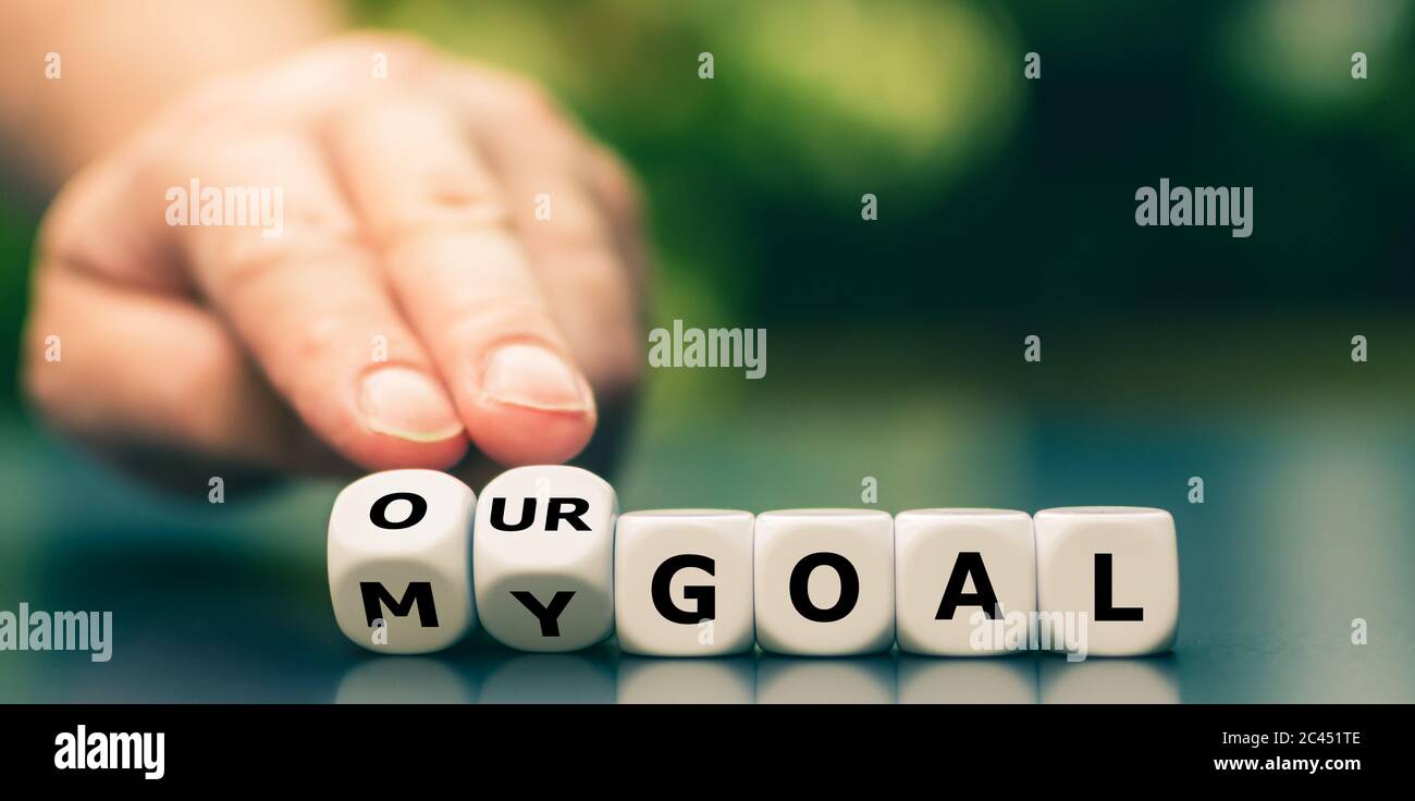 Hand turns dice and changes the expression "my goal" to "our goal Stock ...