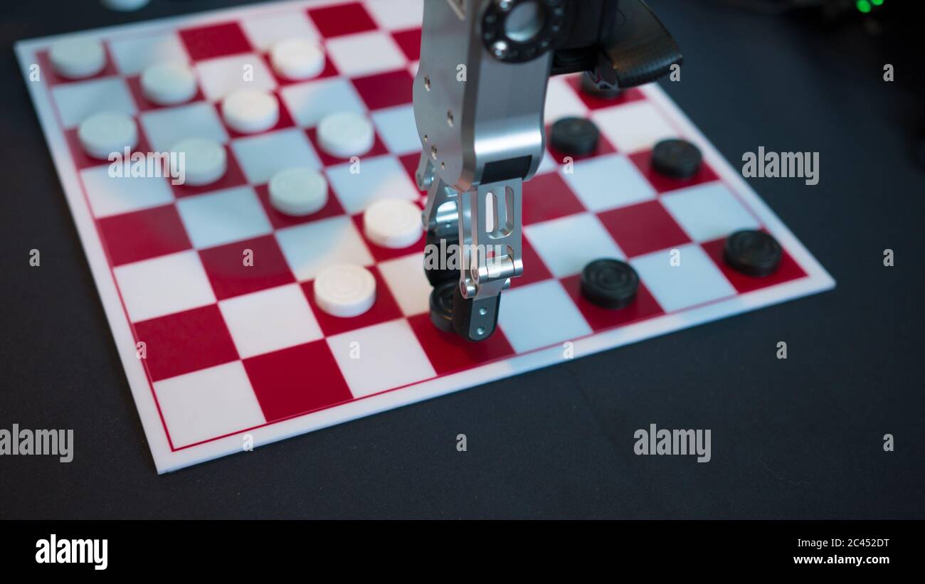 Robot playing checkers. Hand manipulator moves checkers Stock Photo - Alamy
