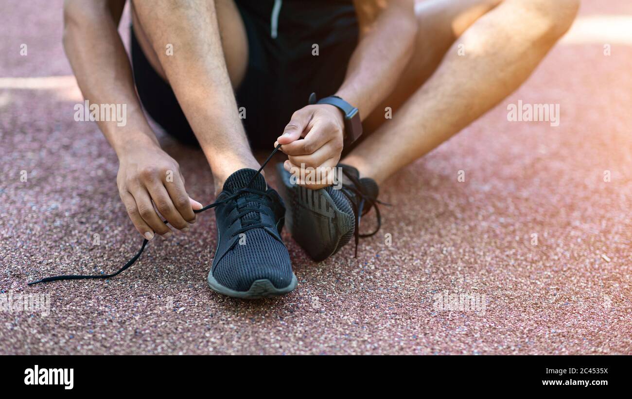 Millennial runner tying shoelaces hi-res stock photography and images ...