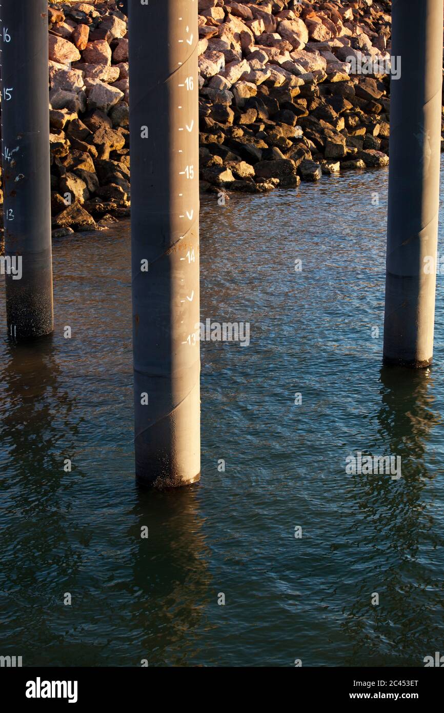 Piles with water level indicators in the water Stock Photo - Alamy